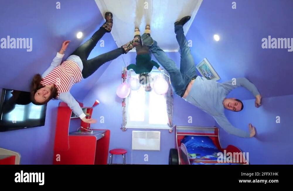 Father, mother and playing kids with balloons at inverted house Stock ...