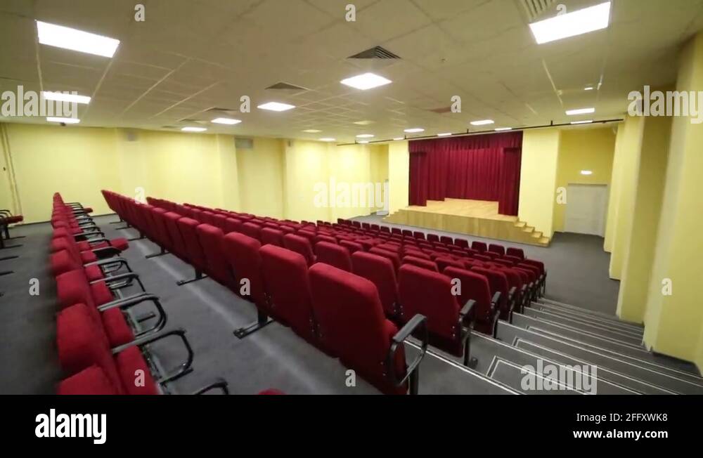 Simple and small auditorium with red armchairs and wooden stage Stock ...