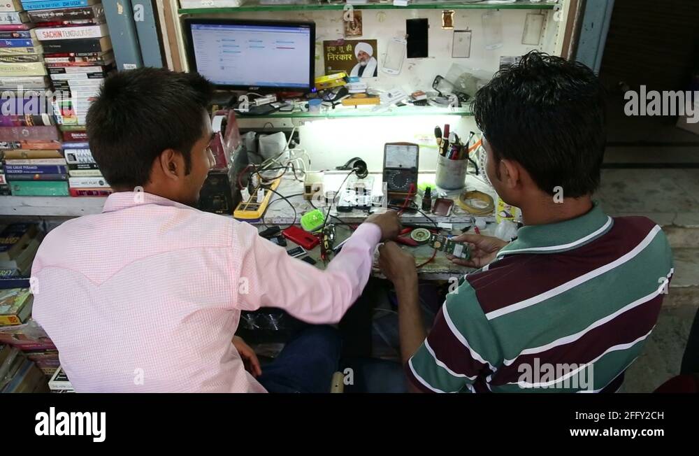 Indian men working in electronics workshop in Mumbai, back view Stock ...