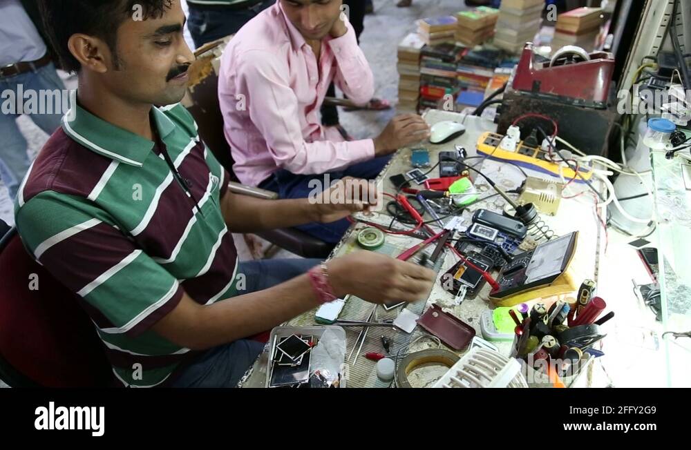 Indian men working in electronics workshop on the street in Mumbai ...