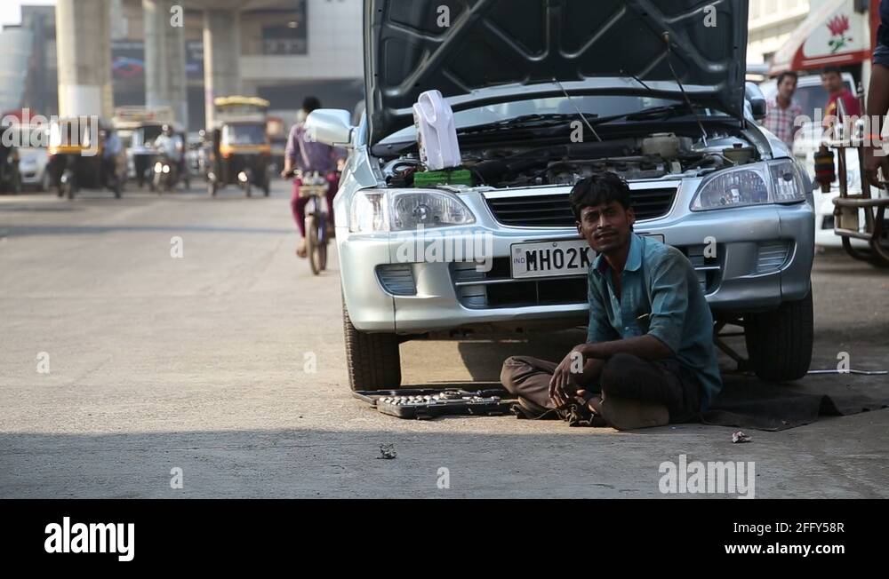 Indian man repairing a car at a busy street in Mumbai Stock Video ...