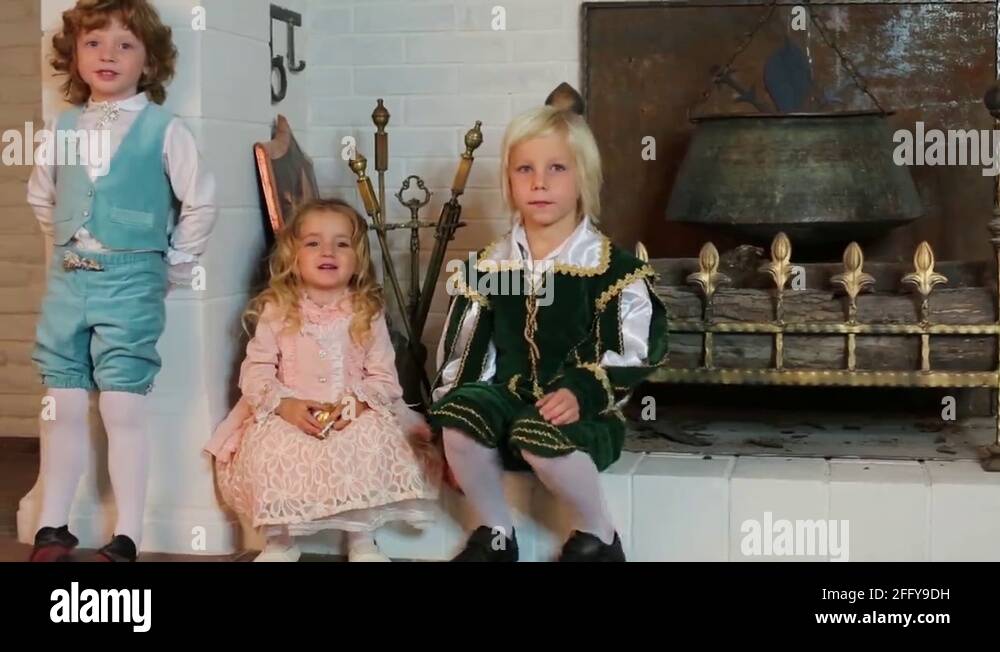 Two boys and girl in medieval costumes pose near fireplace Stock Video ...