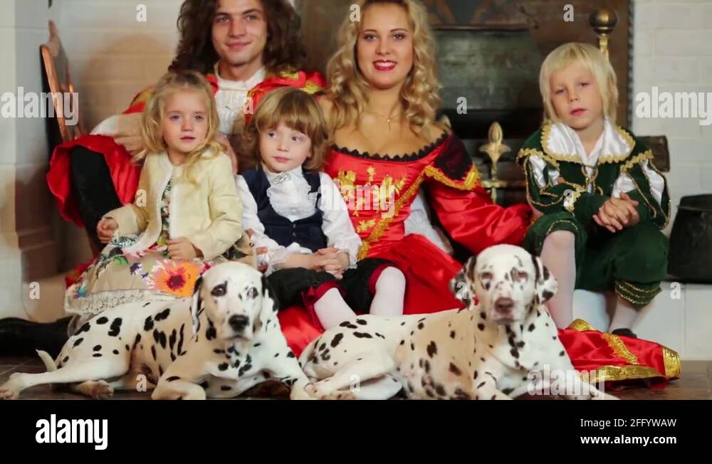 father, mother, little daughter and two sons sit with two dalmatians ...