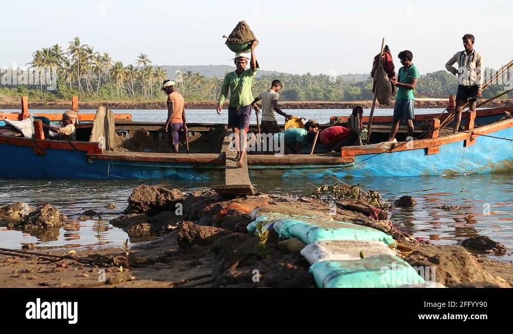 Men taking sand out of a sinking boat in Goa Stock Video Footage - Alamy