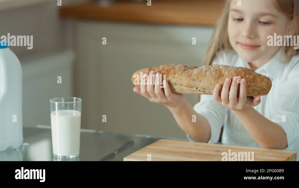 Young girl holding a loaf of bread. Girl looking at camera and smiling ...