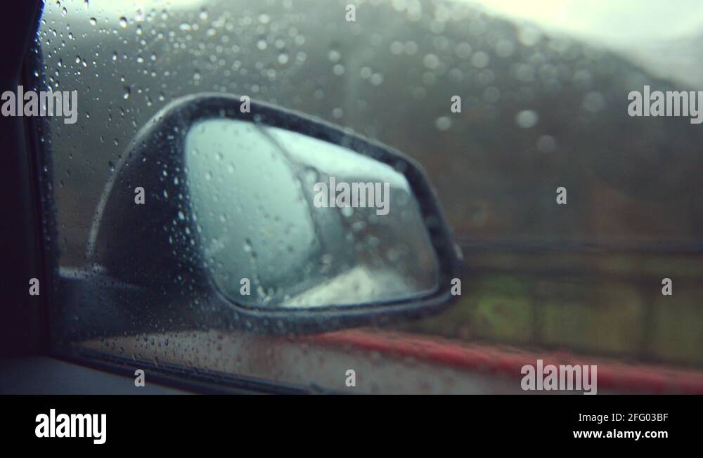 Man driving the car in rainy weather. Rain splatters car windshield ...