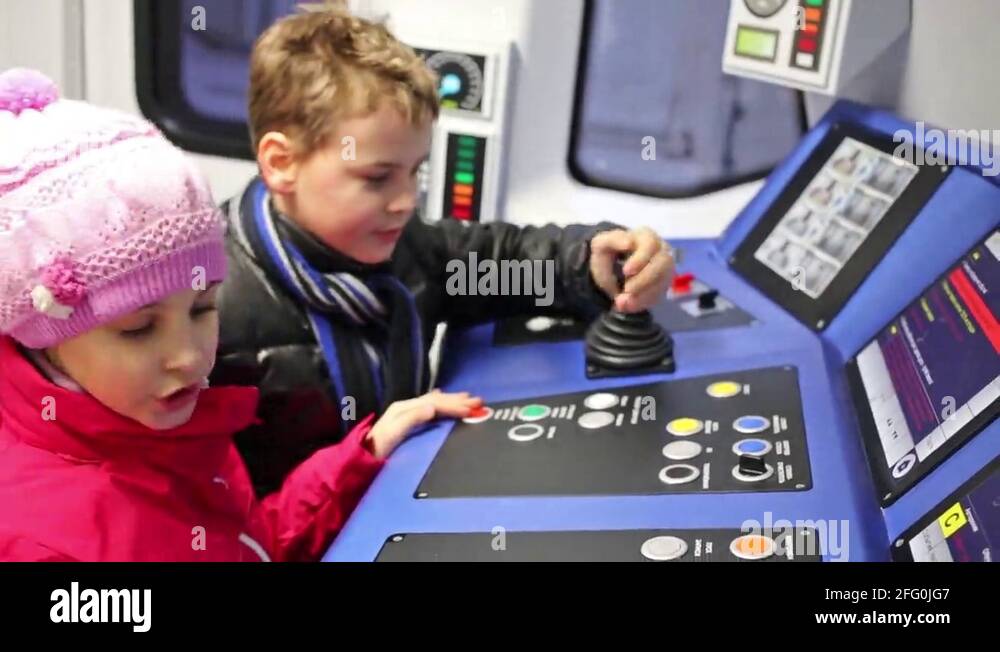 Two children have fun with control panel of subway train simulator ...