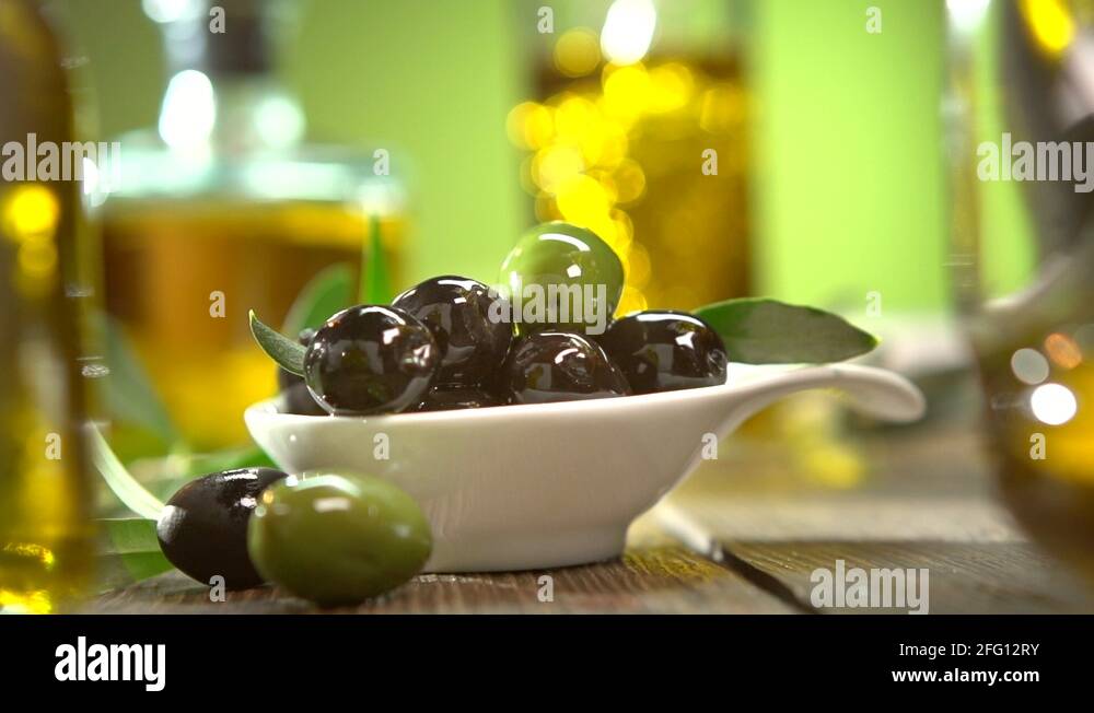 Olives and pouring olive oil. Extra virgin olive oil pouring from the ...