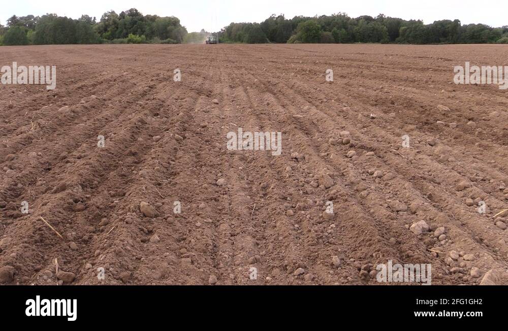 Soil and tractor fertilize field. Planting sow crops Stock Video ...