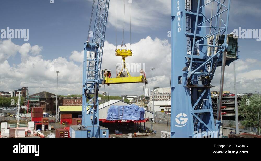 Industrial crane loading and unloading cargo containers at a busy port ...