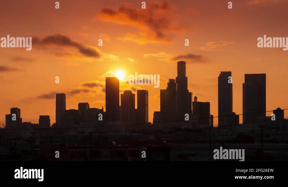 Beautiful sunset sun behind downtown Los Angeles city skyline. 4K UHD ...