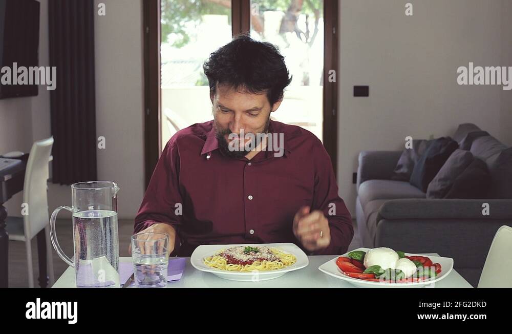Happy italian man smelling spaghetti with tomato sauce before eating at ...