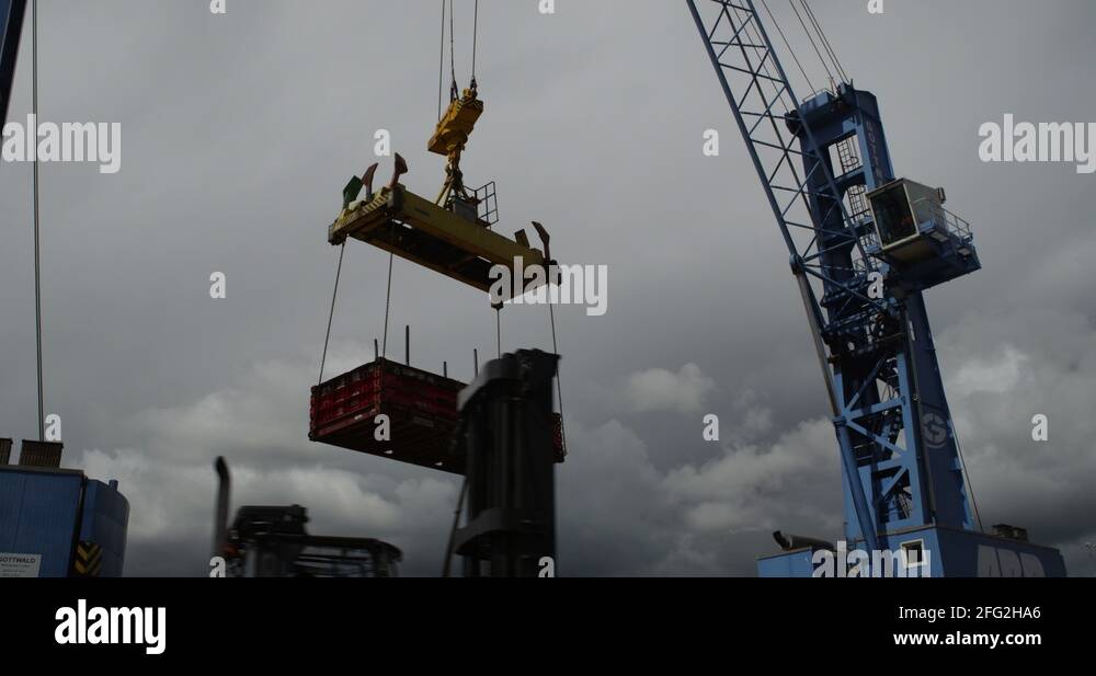 Industrial crane loading and unloading cargo containers at a busy port ...