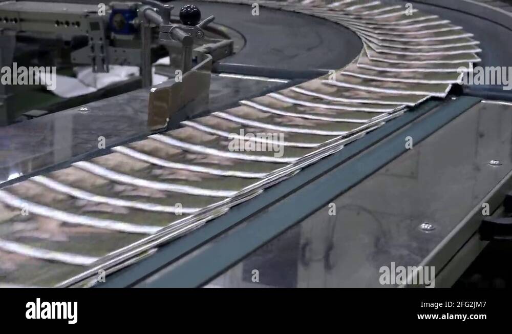 Newspapers flow along an assembly line in a newspaper print factory ...