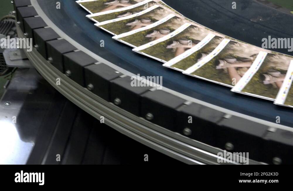 Newspapers flow along an assembly line in a newspaper print factory ...