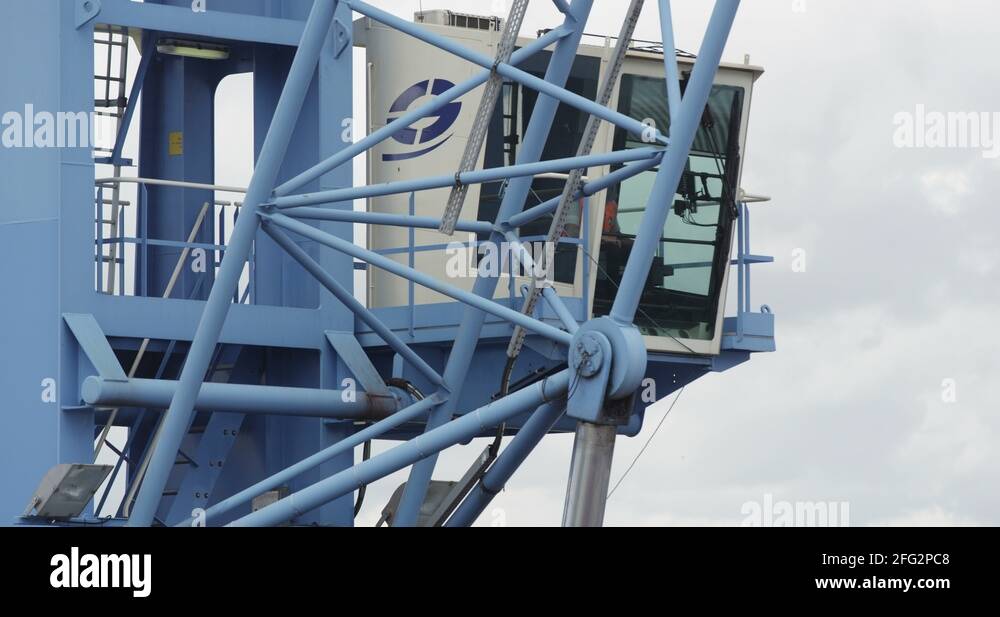 Crane operator loading and unloading cargo containers at a busy port ...