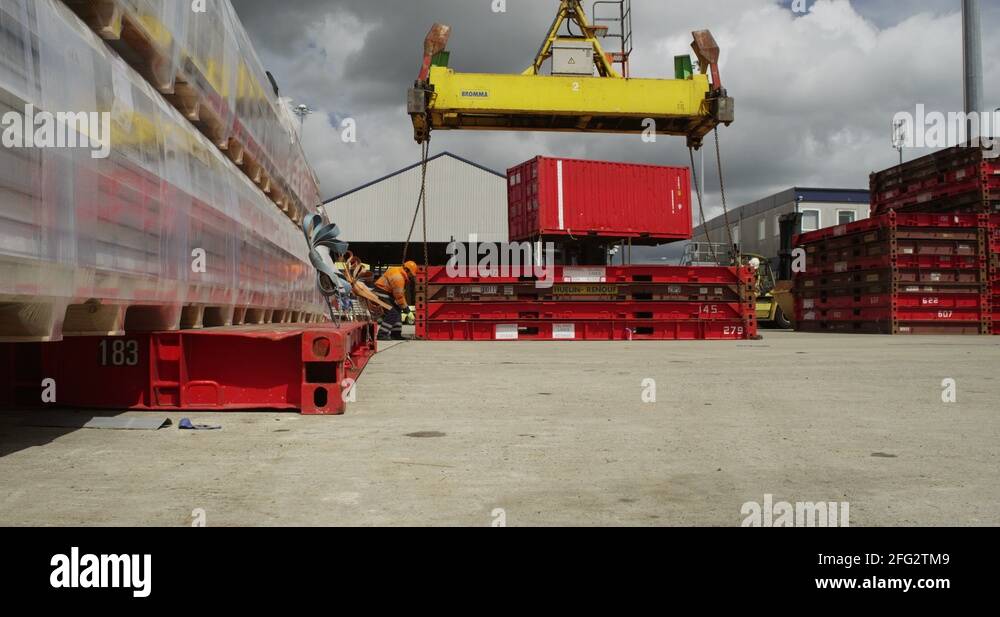Industrial crane loading and unloading cargo containers at a busy port ...