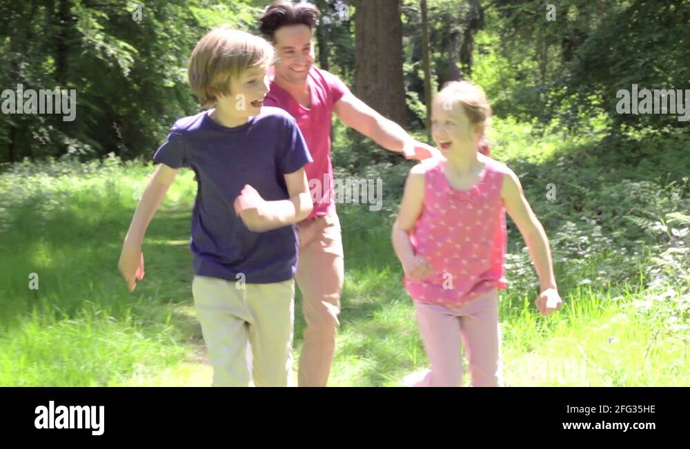 Father Chasing Children Along Woodland Path Stock Video Footage - Alamy