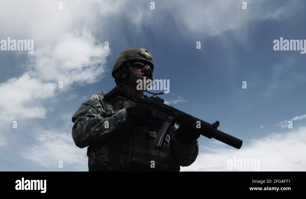 Soldier with sub-machine gun down, aiming, firing, and lowering weapon ...