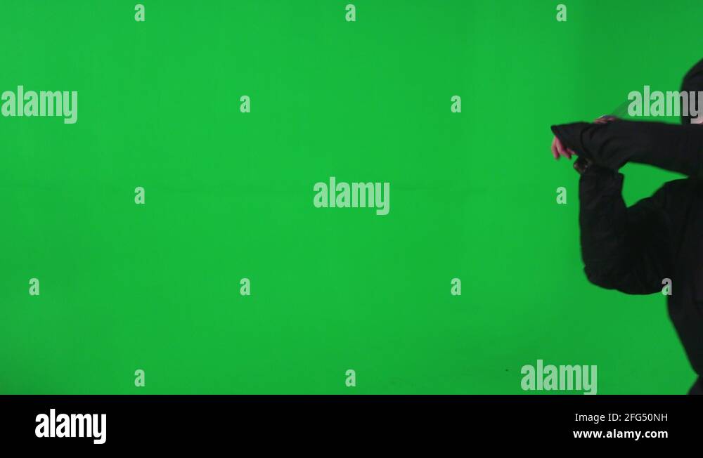 Slow motion green screen shot of a combative ninja brandishing a katana ...