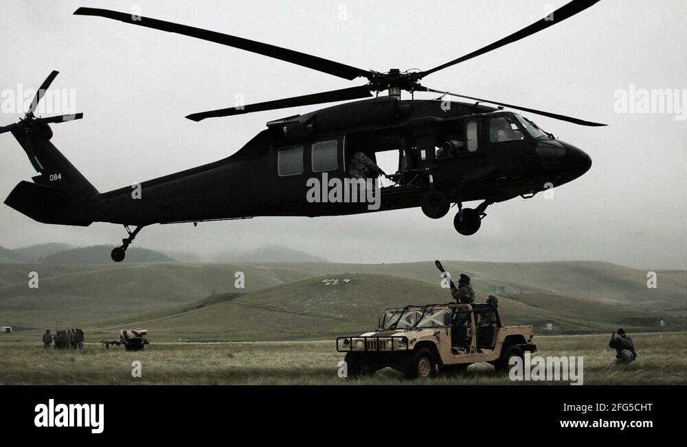 Shot of Black Hawk helicopter attaching and hauling off Humvee from ...