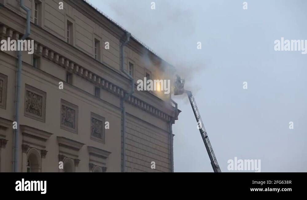 Firefighter on a ladder extinguishes the staging fire on fire drills ...