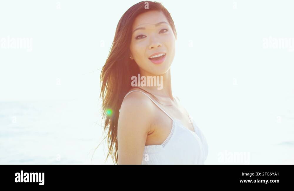 Portrait of smiling Asian Chinese girl in white sundress on island ...