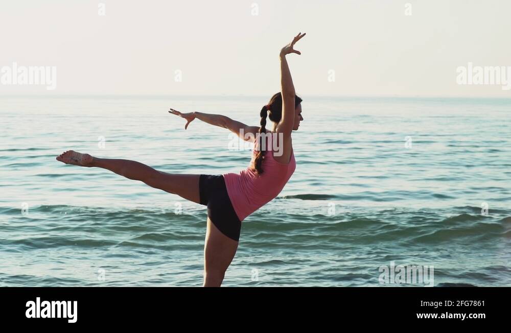 young female does gymnastics on the beach slow motion Stock Video ...