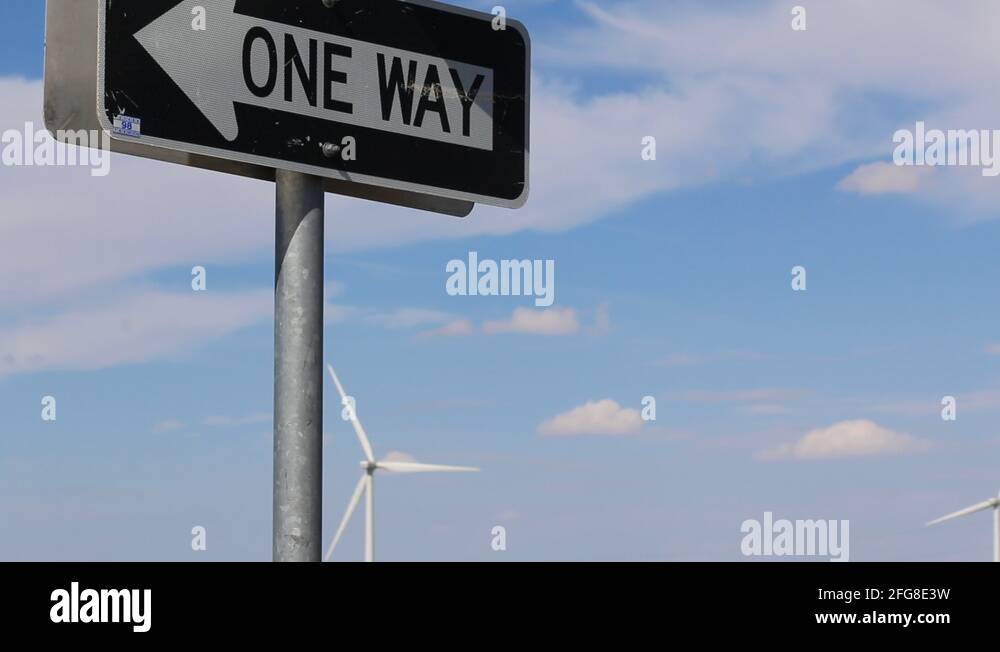 One Way Road Sign with Wind Turbine Blades in Background Stock Video ...
