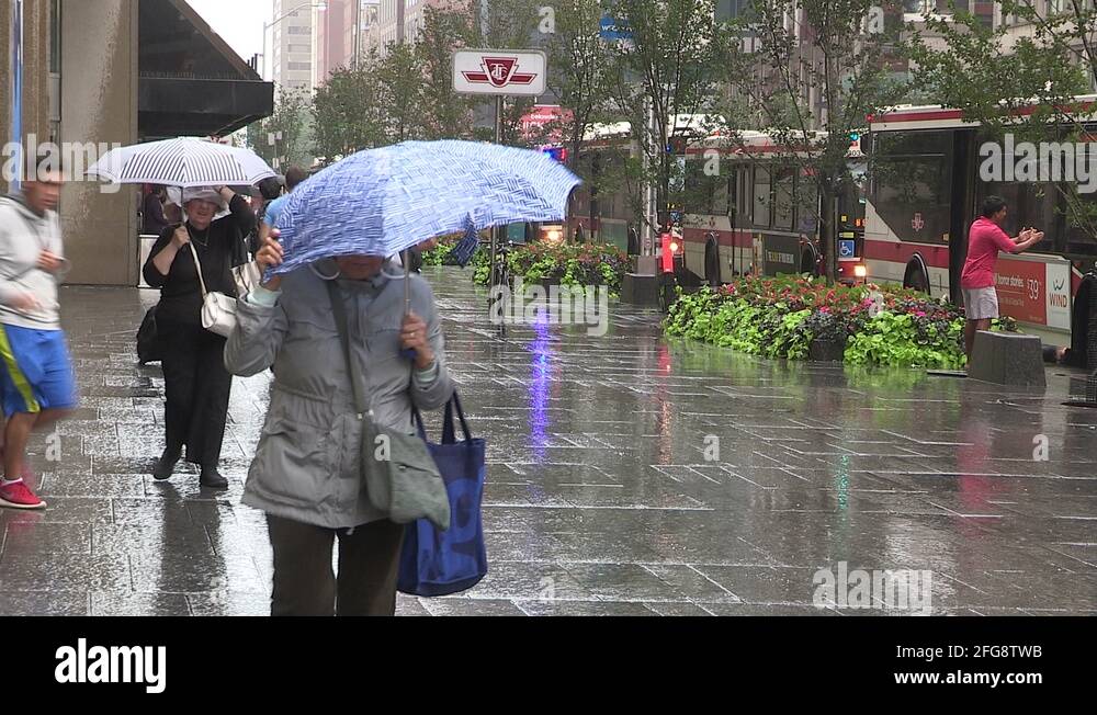People running for cover in heavy rain wind storm in downtown Toronto ...