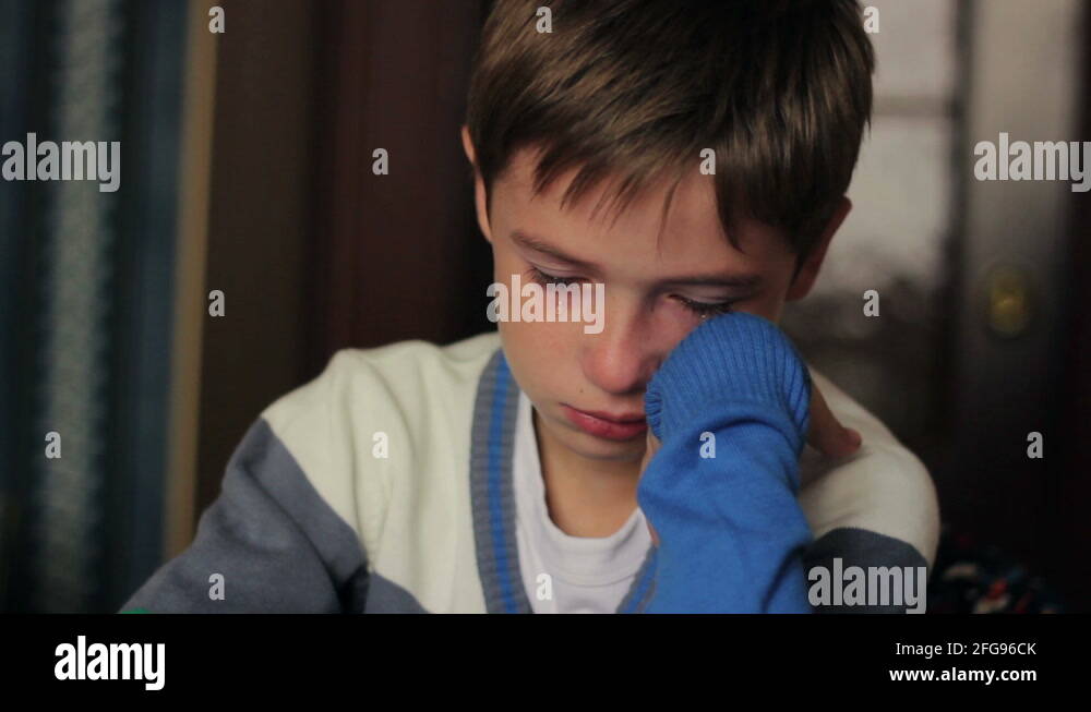 little boy sitting at a desk crying, tears on his face Stock Video ...