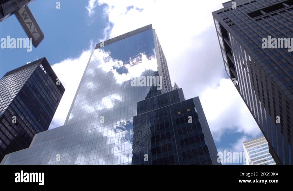 A large glass skyscraper reflects the sun and clouds in New York City ...