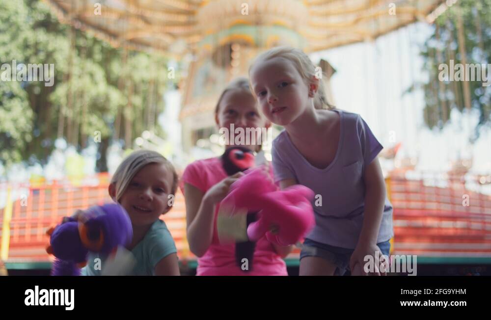 Three little girls at a fair showing their prizes to the camera Stock ...