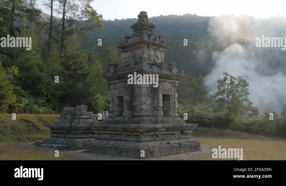 Ancient hindu temple with smoke from spring,Gedung Songo,Java,Indonesia ...