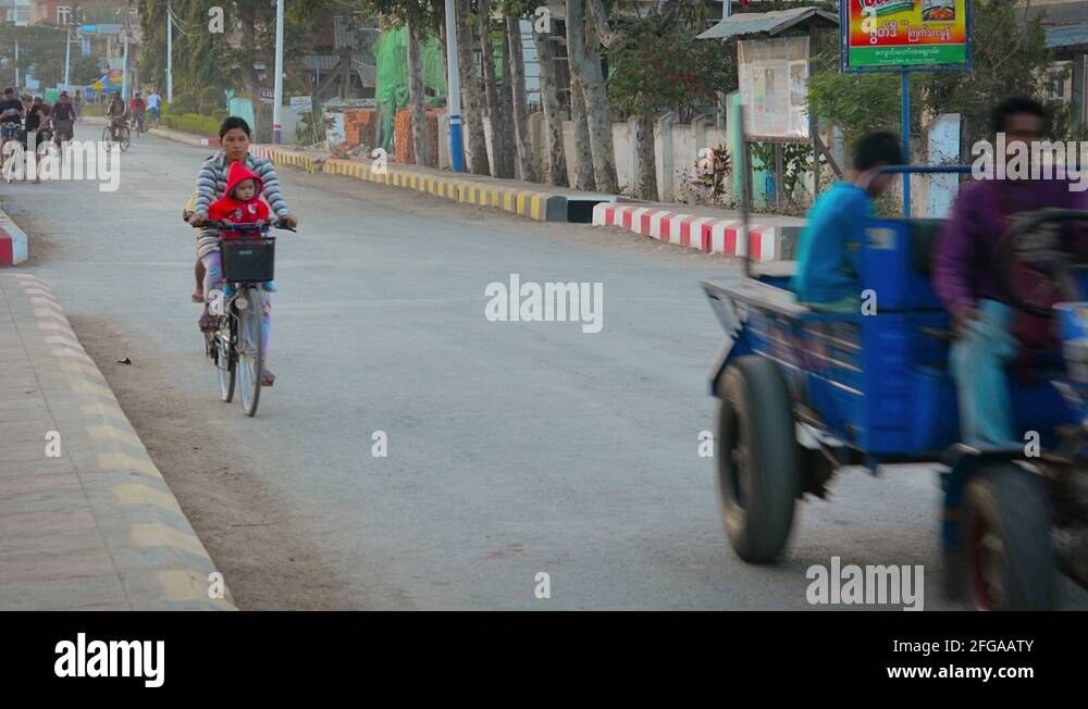 Bicycles, motorcycles and a tractor, rolling down a city street in ...