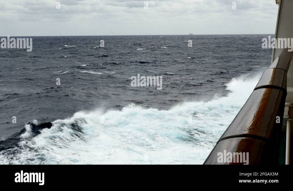 Ocean with ship railing and bow spray gray overcast day choppy seas ...