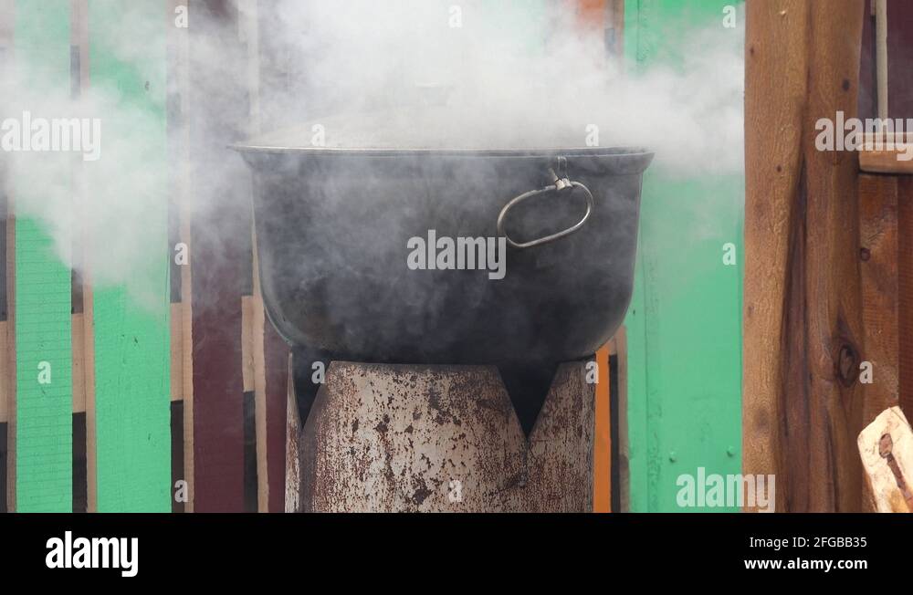 Cast iron pot over an with fire is, there is steam, 4k Stock Video ...