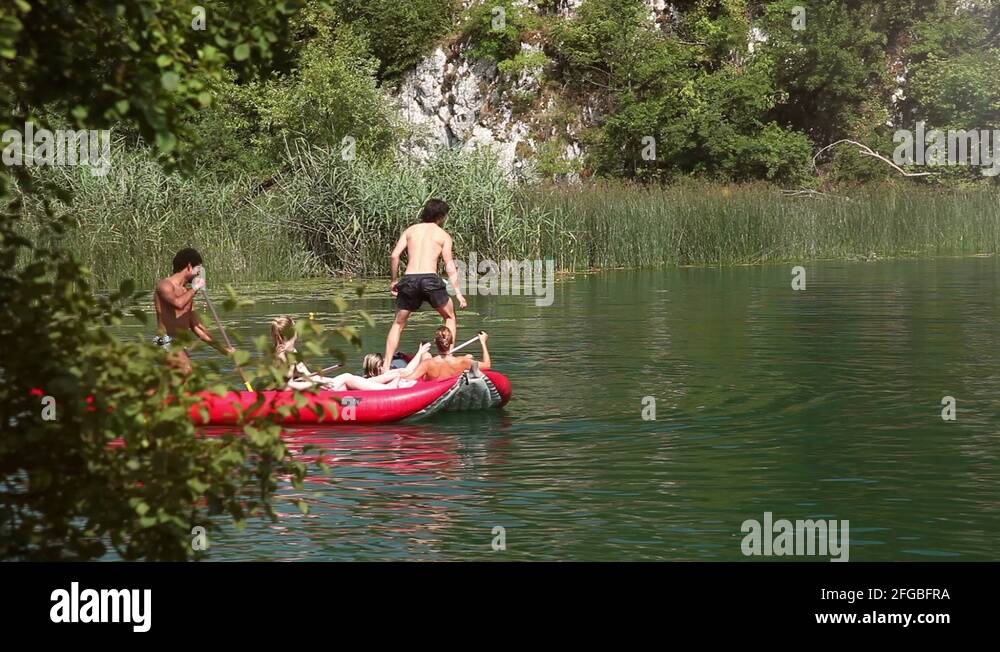 Man jumping off canoe into river, friends laughing Stock Video Footage ...