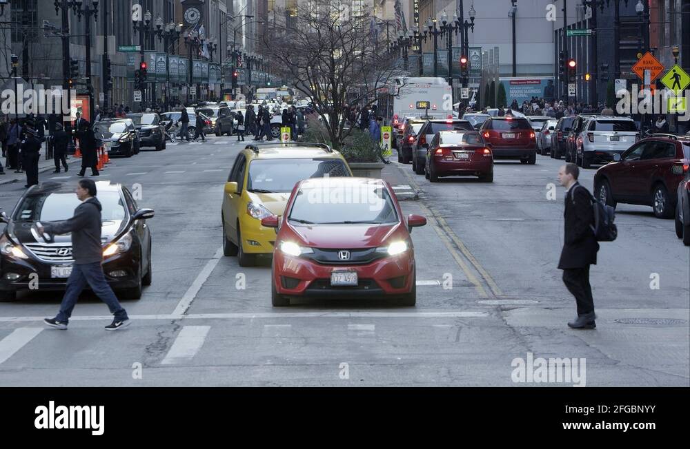 Traffic stopped at an intersection in downtown Chicago. Camera tilts up ...