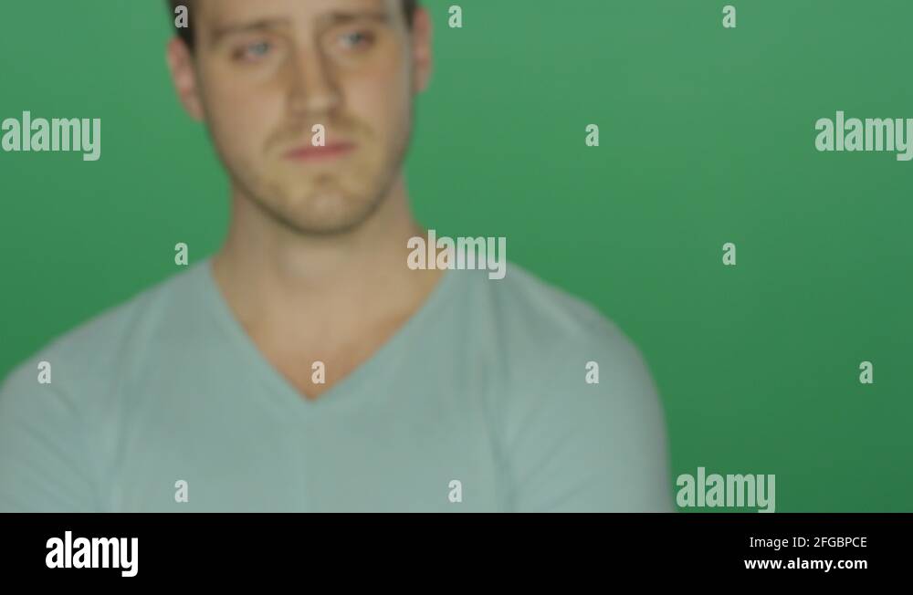 Sad young man starting to cry, on a green screen background Stock Video ...