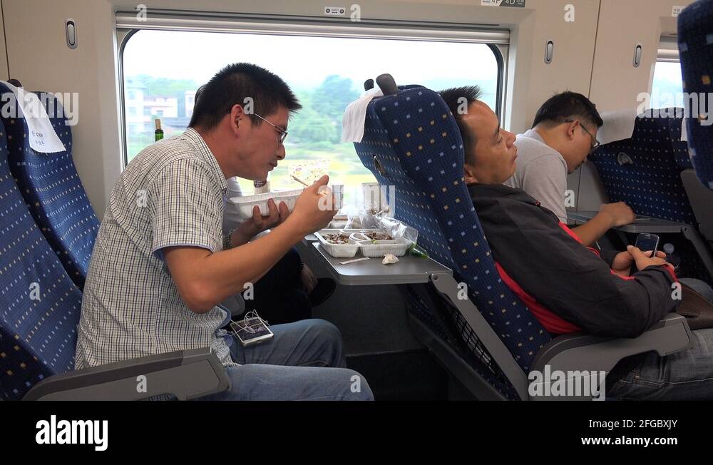 Two Chinese men are having lunch inside a riding bullet train Stock ...