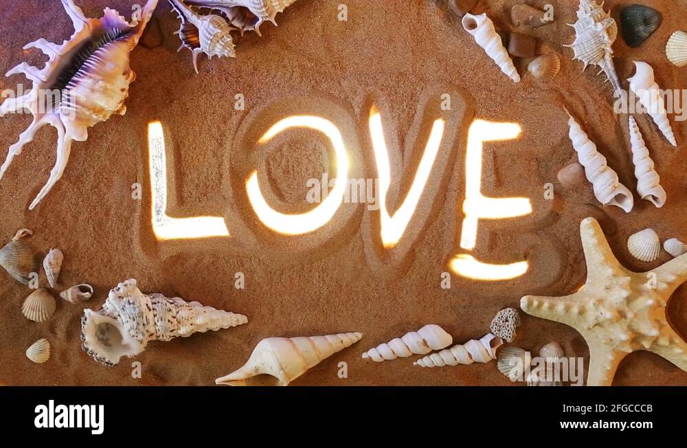 Hand drawing Love symbol in the sand. Beach background. Top view Stock ...