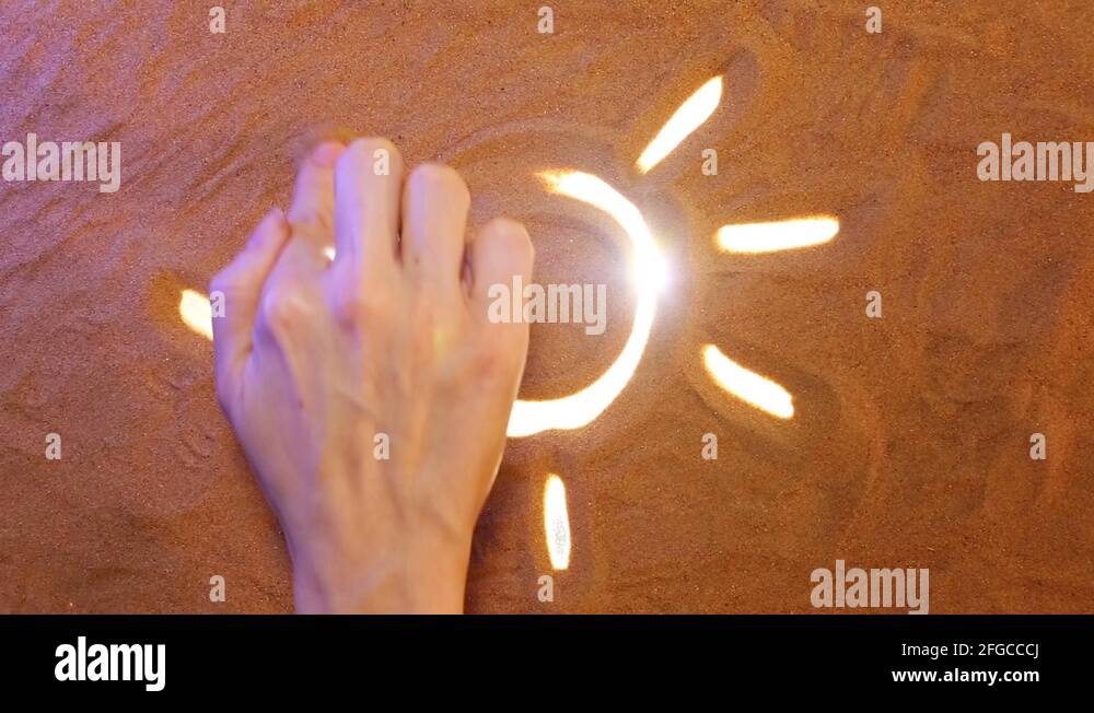 Hand drawing Sun symbol in the sand. Beach background. Top view Stock ...