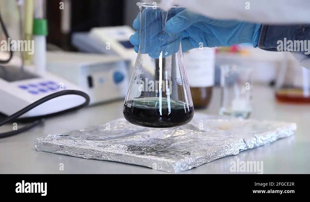 scientist shaking Erlenmeyer Flask with liquid in a laboratory, slider ...
