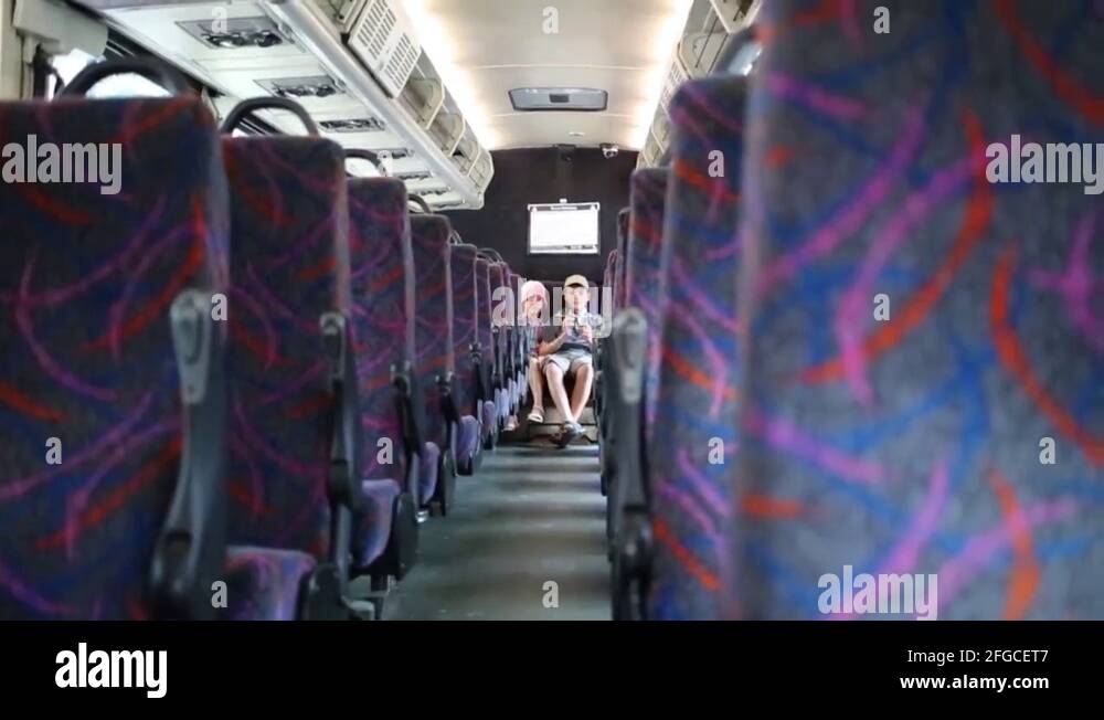 Boy and girl sitting in the back seat of an empty bus Stock Video ...