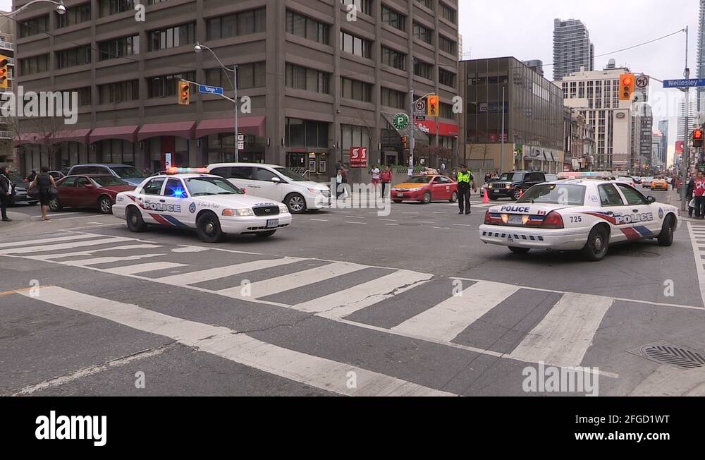 Toronto police officers block off street with police cruiser and bikes ...