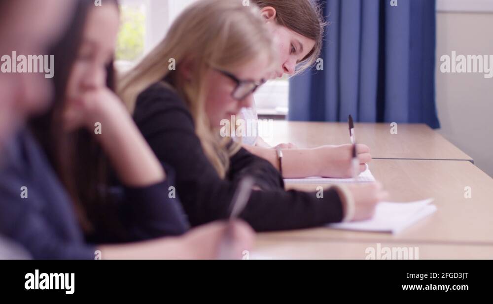 4k, Students in school uniform taking exam at desk in a classroom. Slow ...