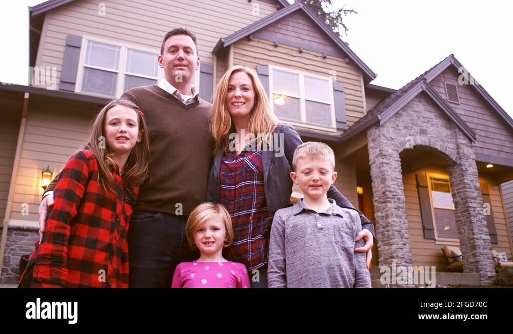 A family poses for a portrait in front of their house Stock Video ...