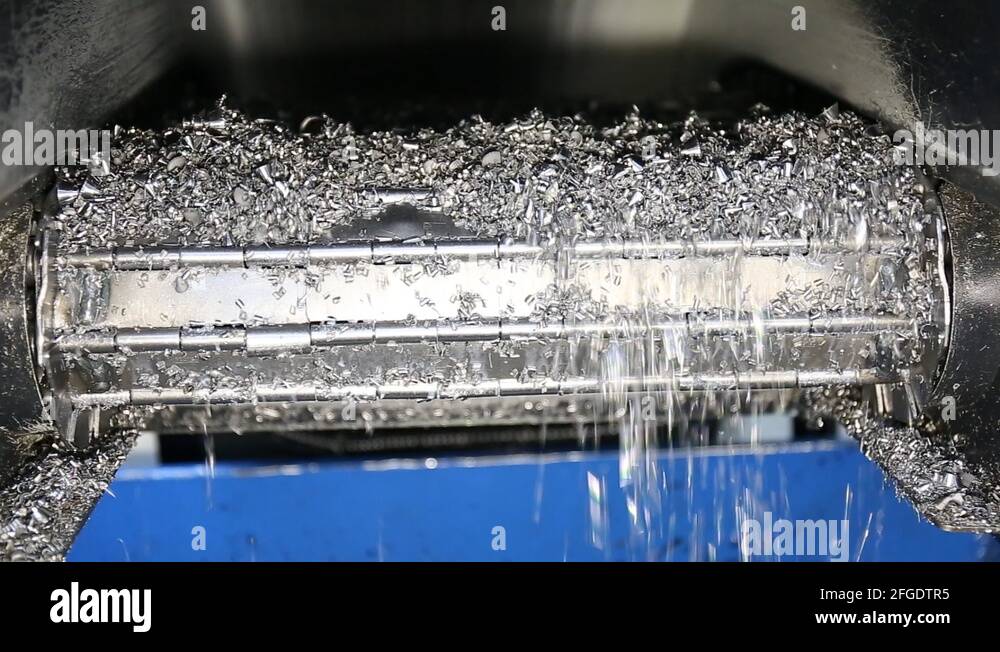 Chip conveyor moving steel chips from coolant tank to the scrap bin ...