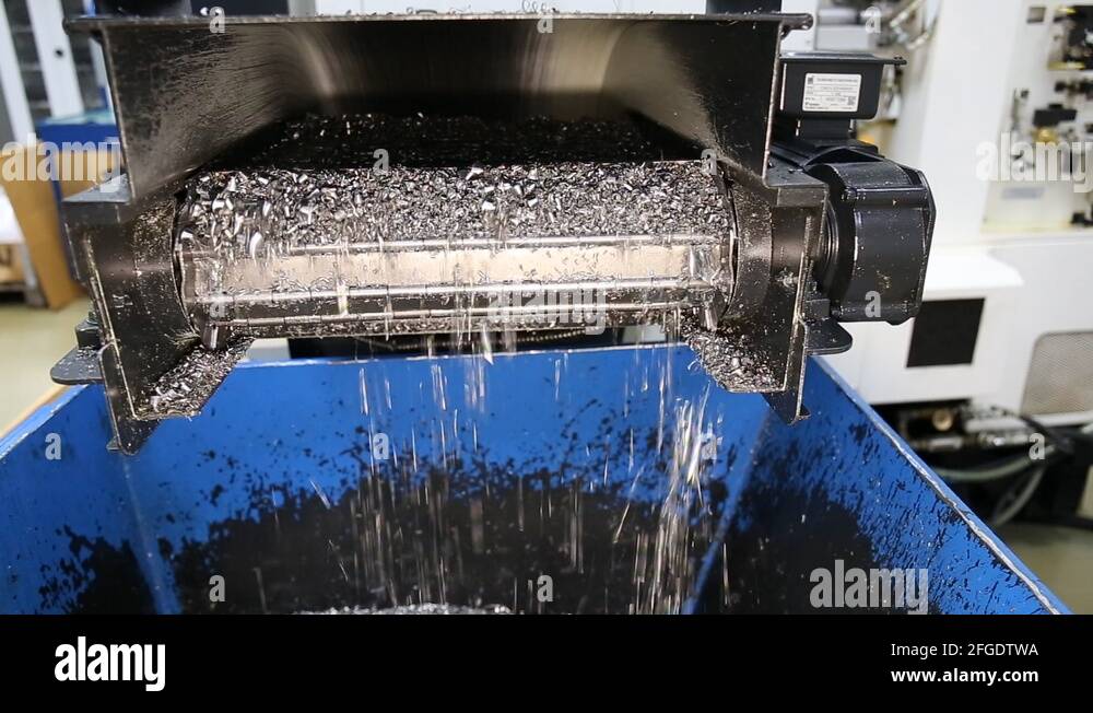 Chip conveyor moving steel chips from coolant tank to the scrap bin ...